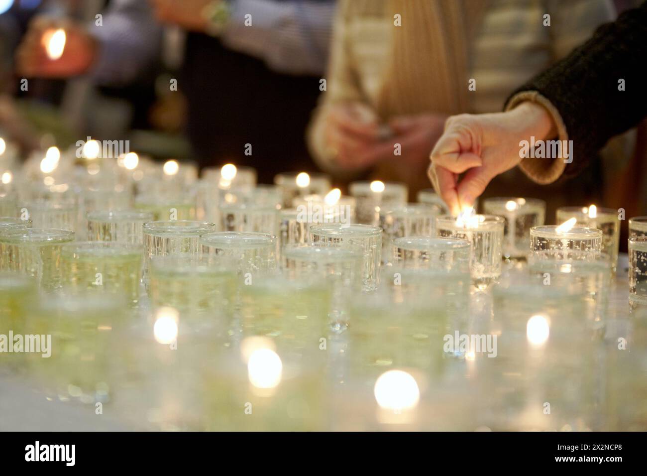 Hands lighting funeral candles Stock Photo - Alamy