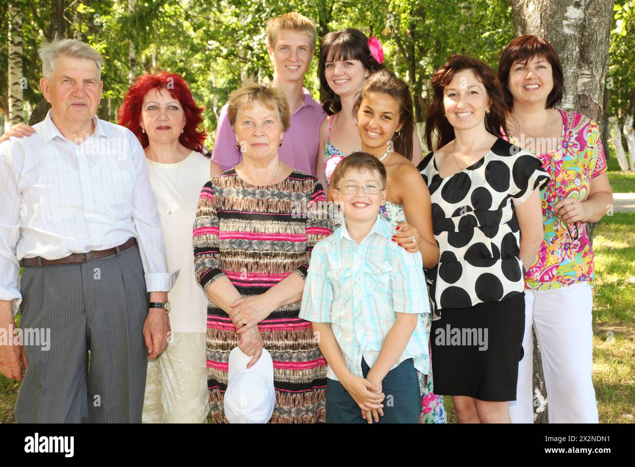 Family of nine people pose at park near big green tree Stock Photo - Alamy