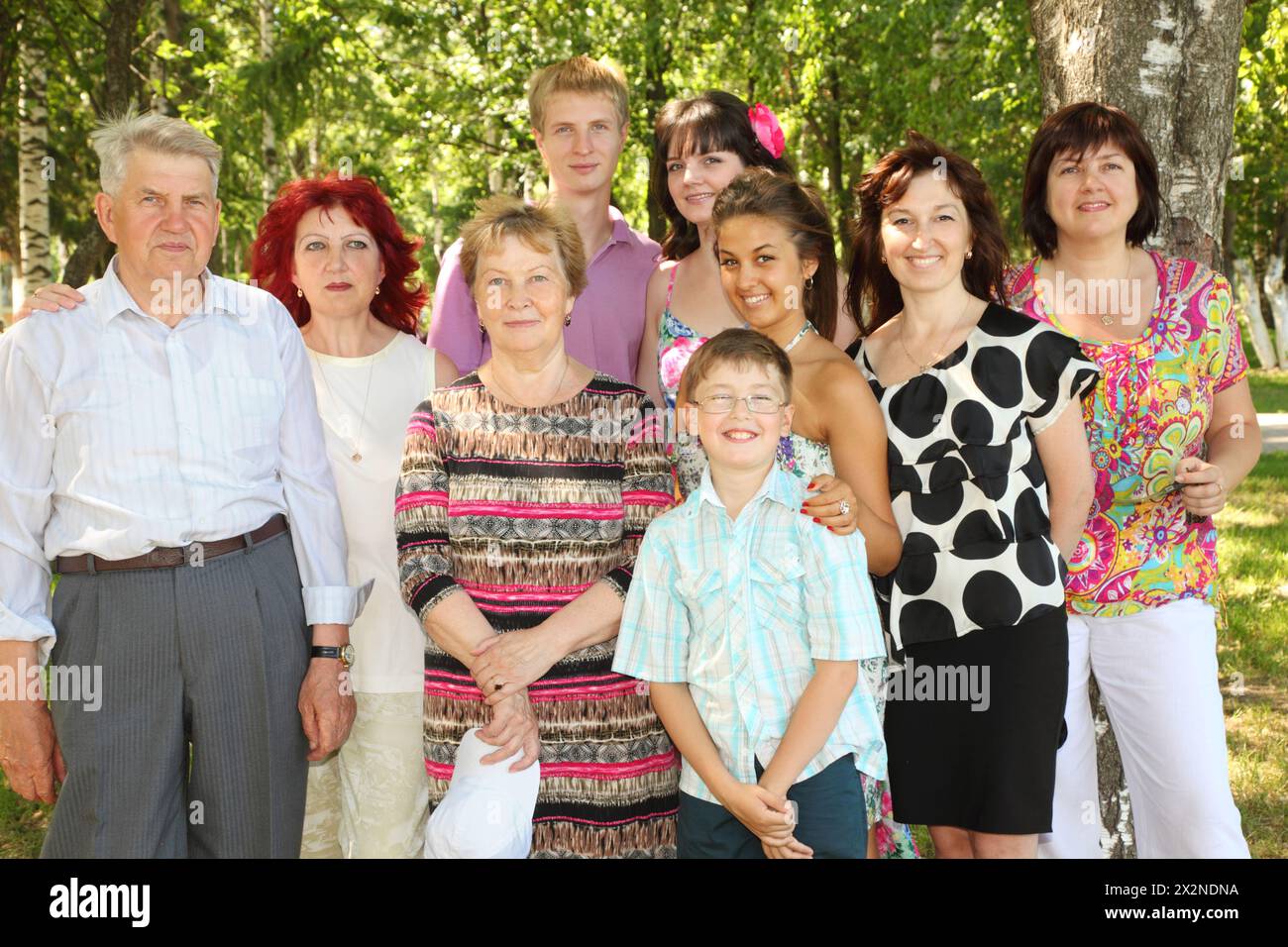 Family of nine people pose at park near big tree Stock Photo - Alamy