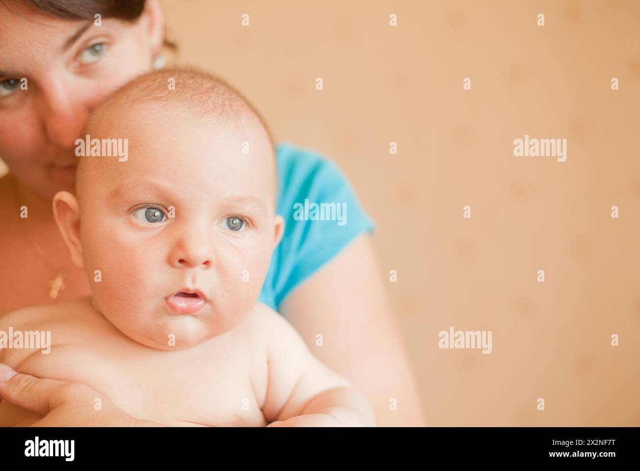 Mom with chain with cross hold baby in hands Stock Photo - Alamy