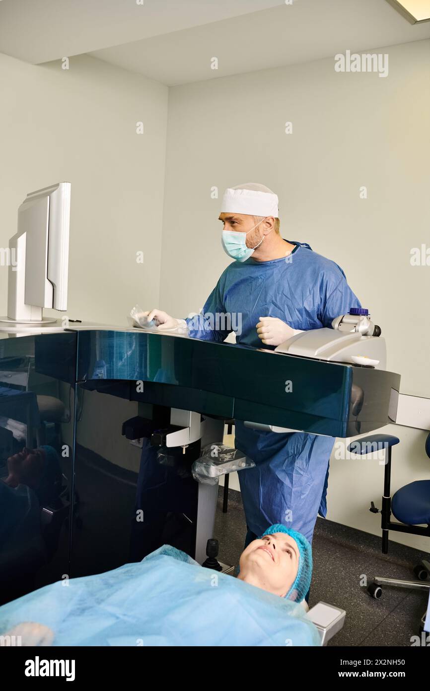 A man in scrubs conducting a computer operation Stock Photo - Alamy