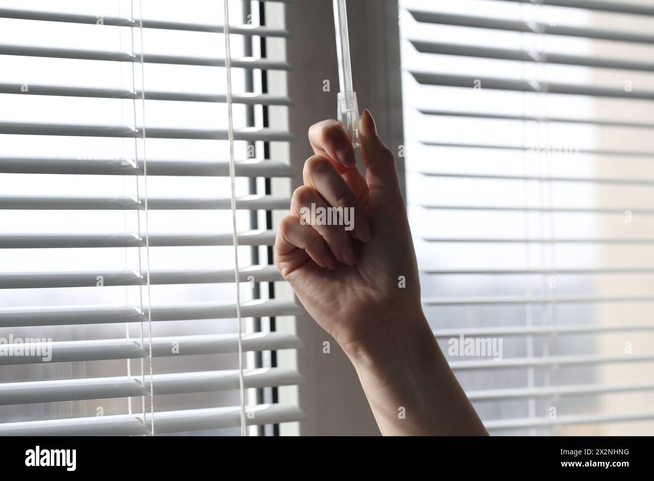 Woman opening blinds hi-res stock photography and images - Alamy