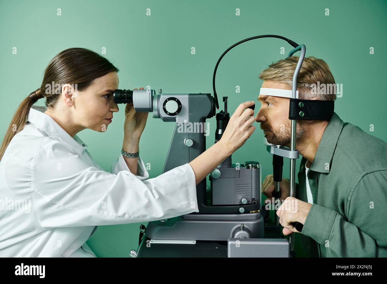Doctor examines mans eyes through a microscope in a doctors office for ...