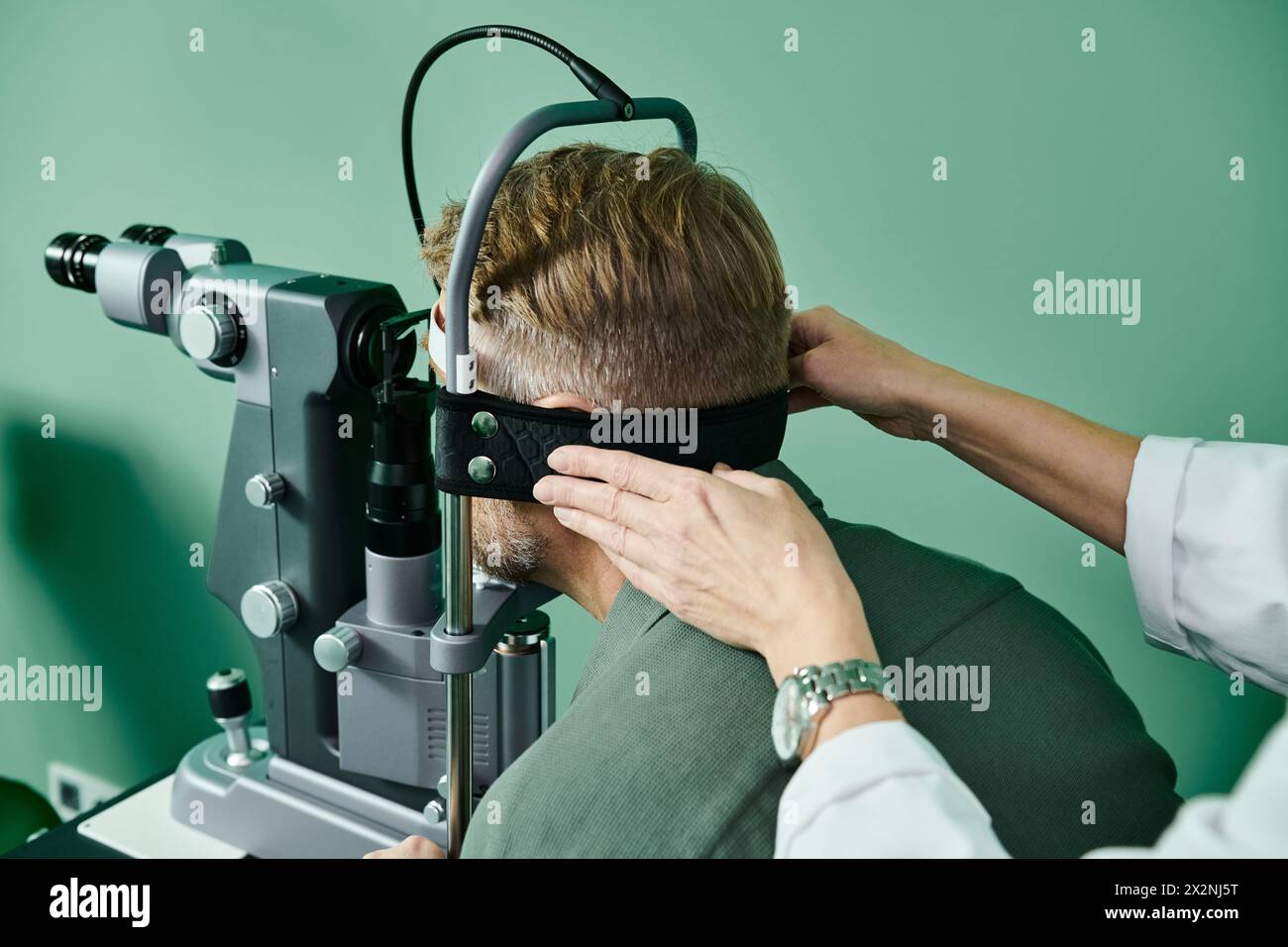 Doctor with wristwatch examines mans eyes in a doctors office for laser ...