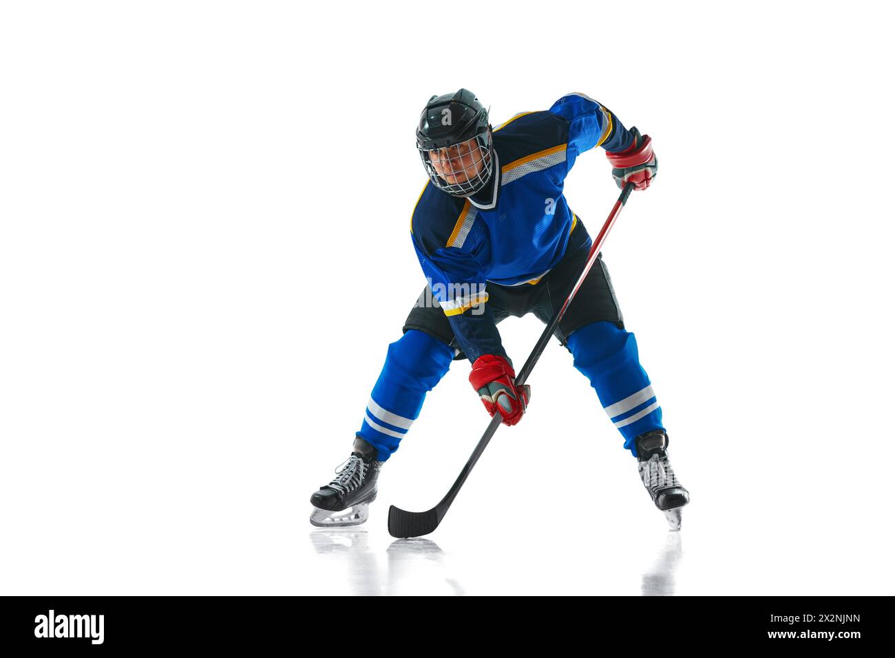 Studio shot of powerful hockey player in full stride, stick low and ...