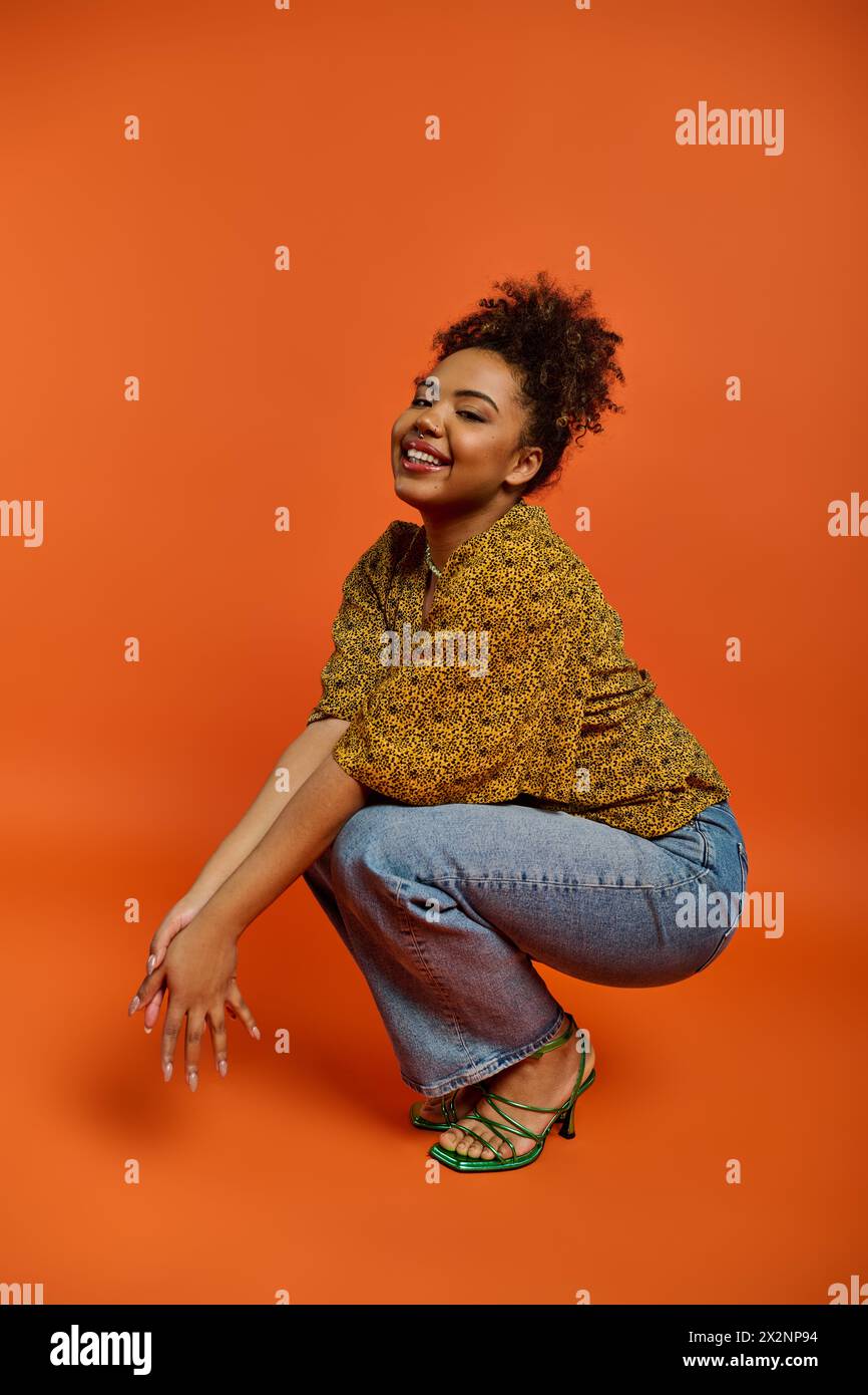 A stylish African American woman kneels with hands raised in an emotive ...
