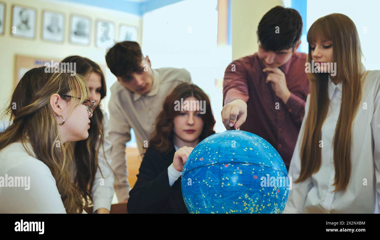 Students look at a globe of the starry sky in a classroom at school ...
