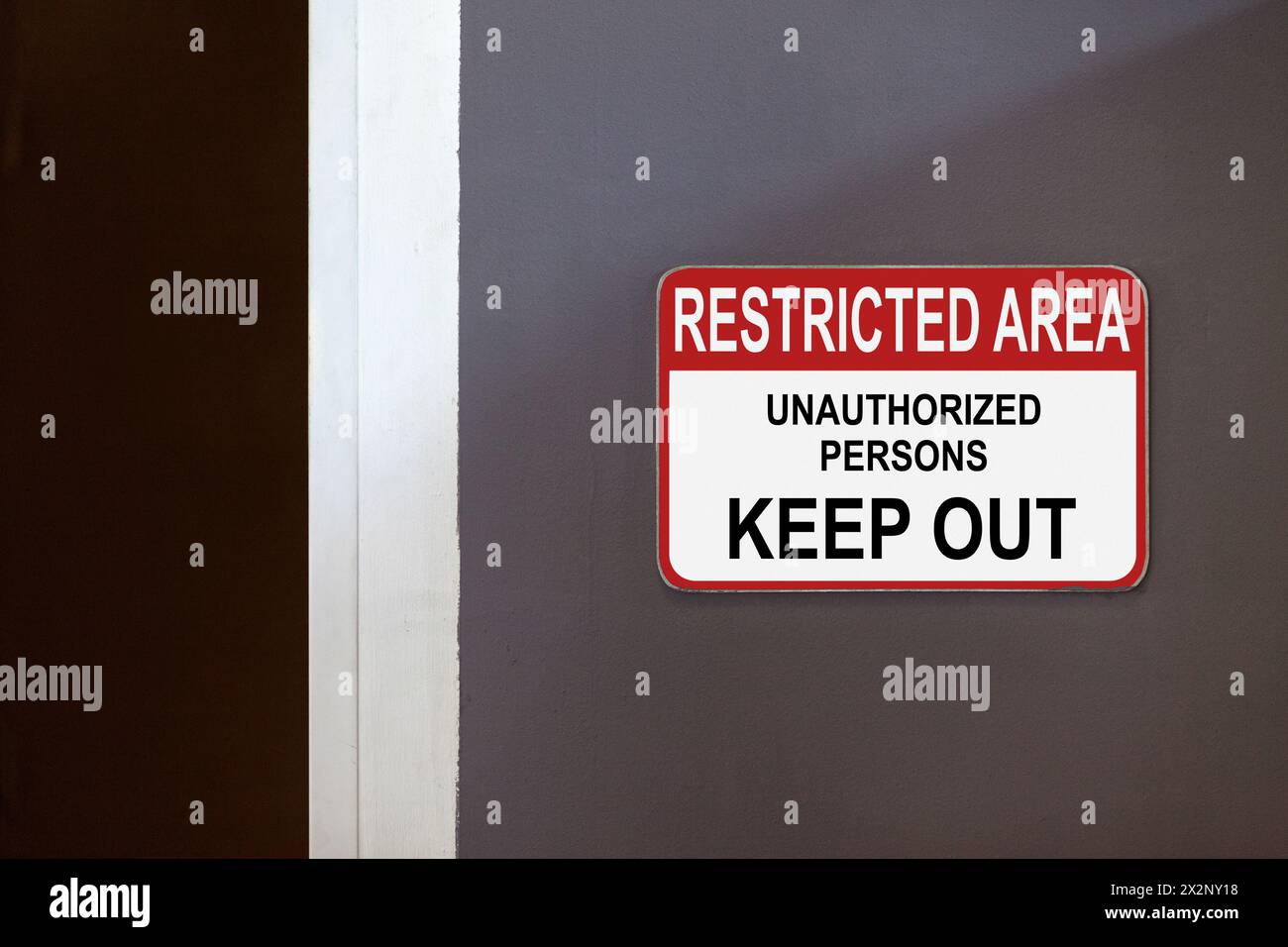 Red and white restricted area sign on the side of a corridor stating ...