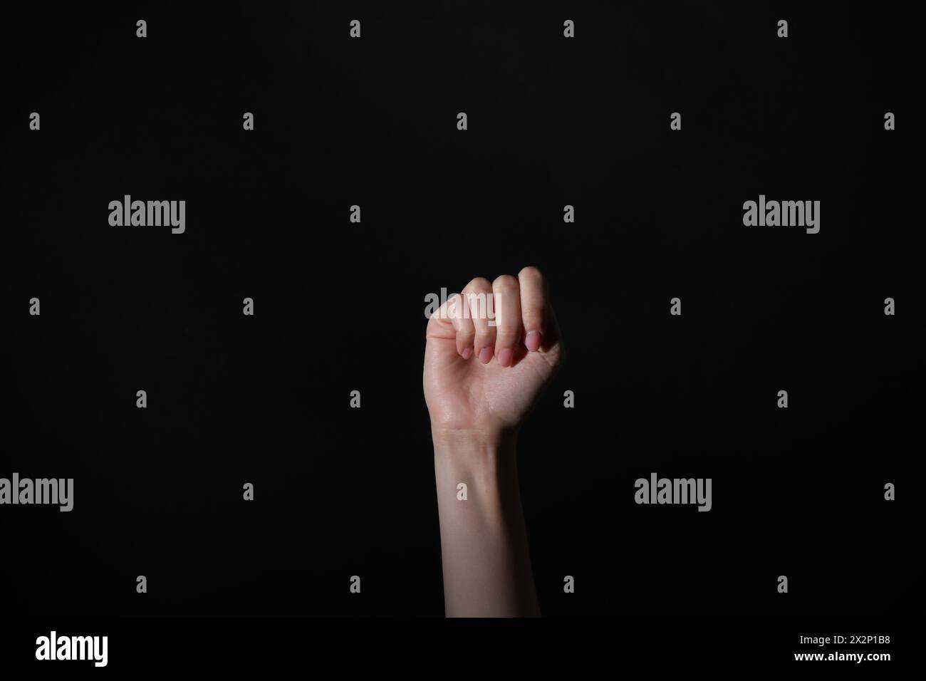 SOS gesture. Woman showing signal for help on black background, closeup ...