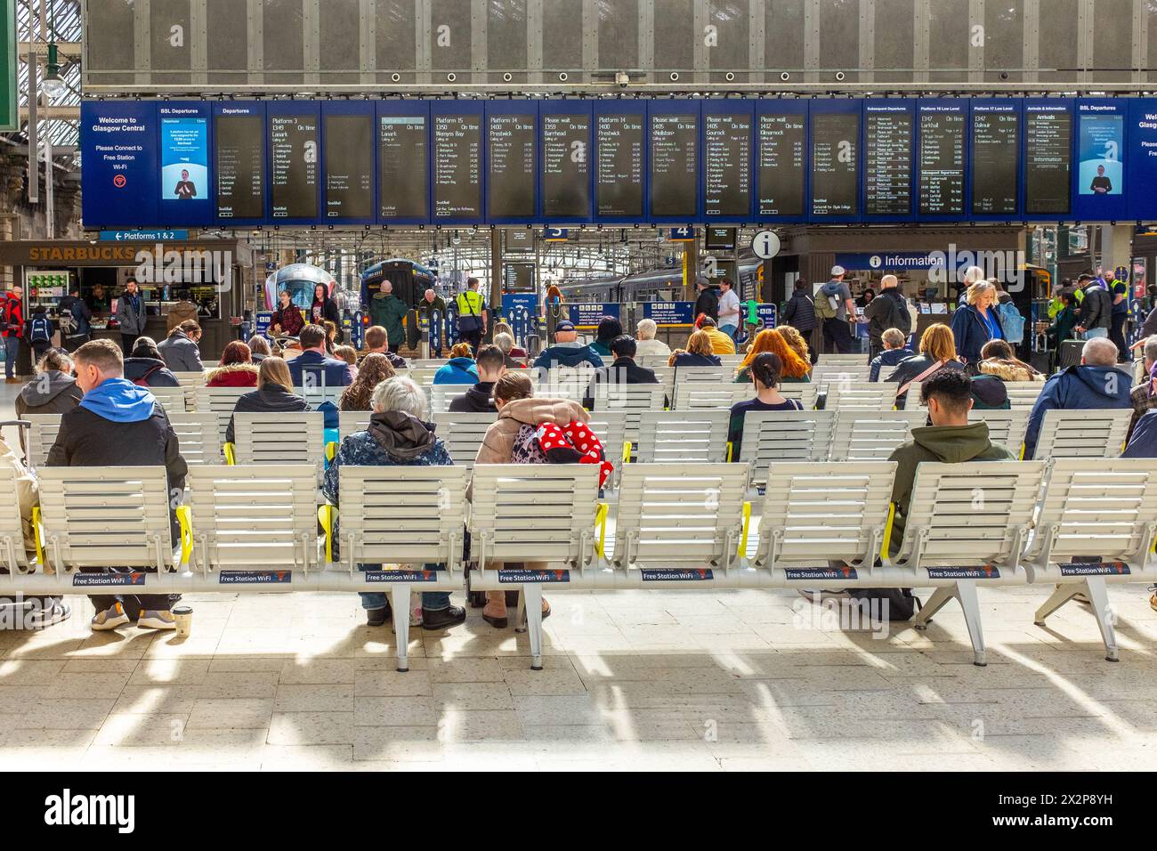 Passengers waiting at Glasgow Central railway station and watching the ...