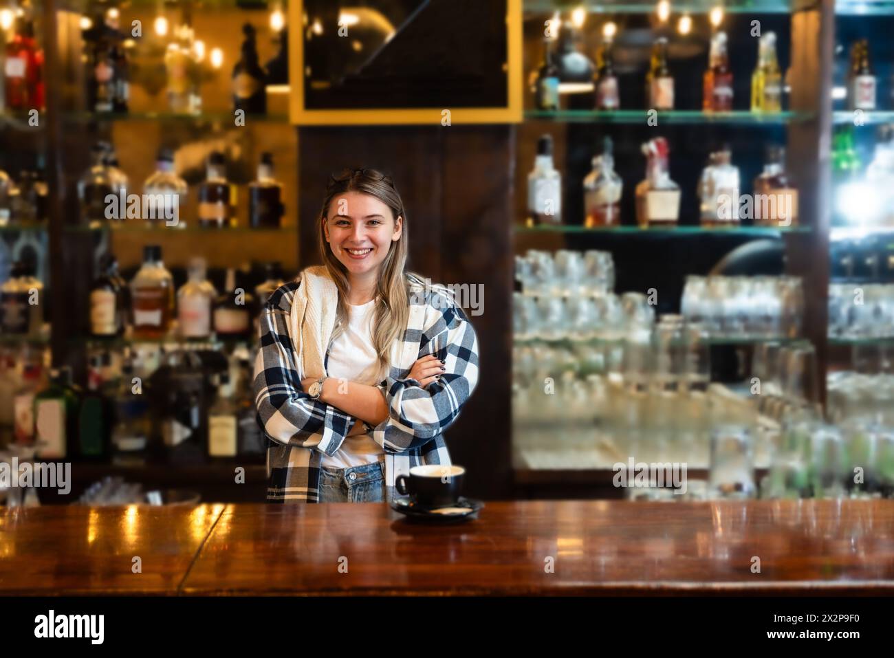 Waitress standing in bar and wiping and polishing beer glass. Bartender ...