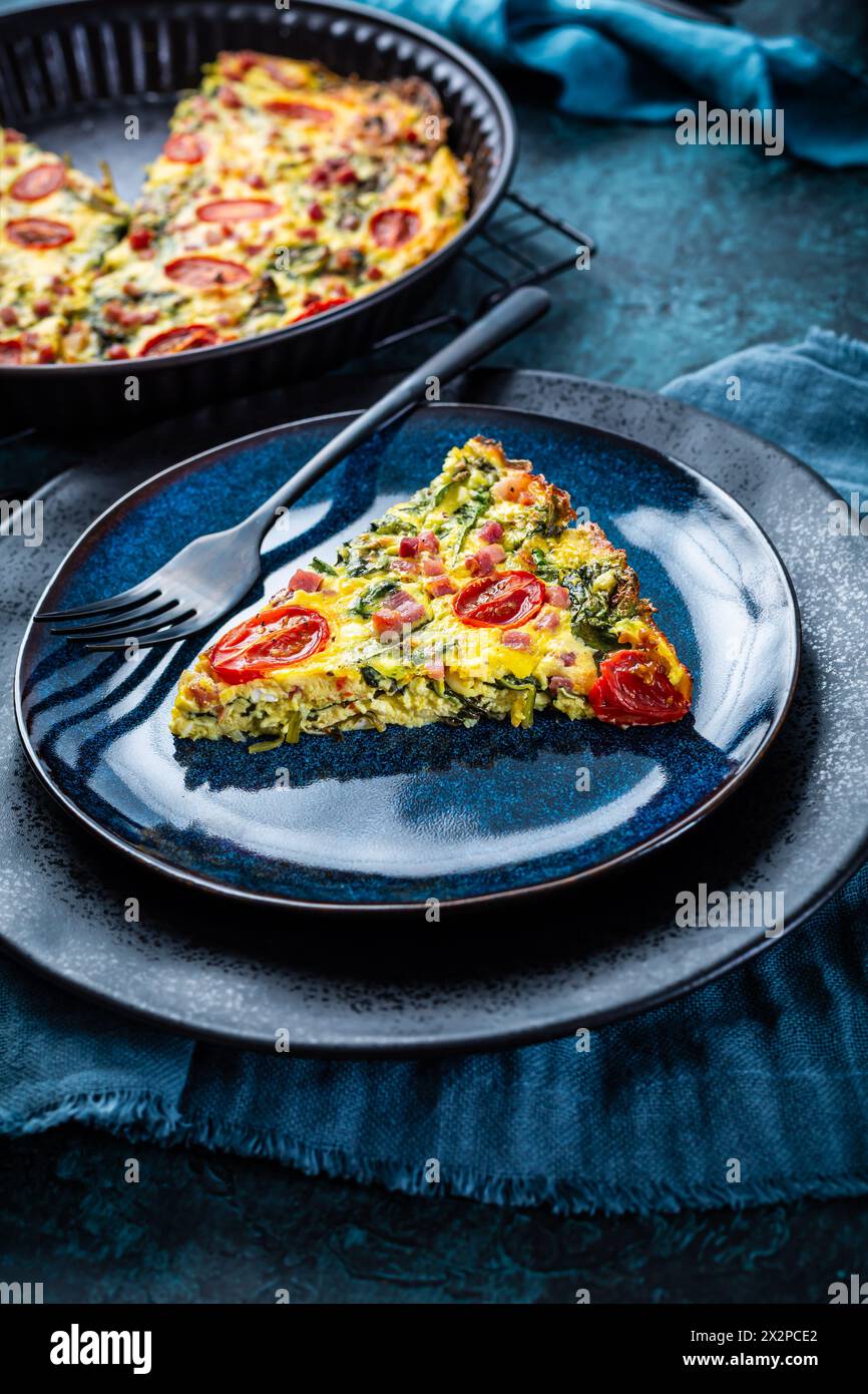 Homemade frittata with spinach, curd cheese, bacon, onion and green ...