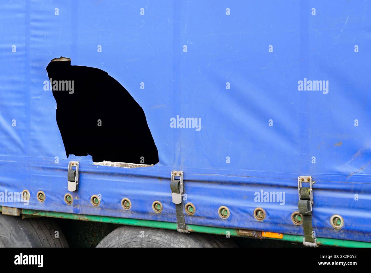 Truck trailer with blue damaged awning, cargo theft problem by cutting ...