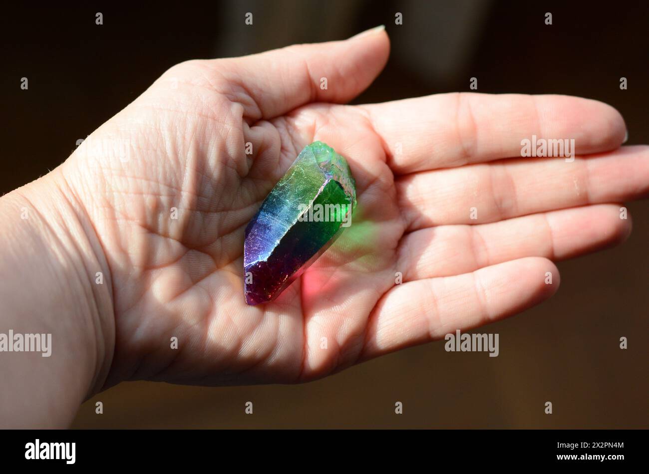 Young woman is holding a rainbow quartz raw mineral gemstone in her ...