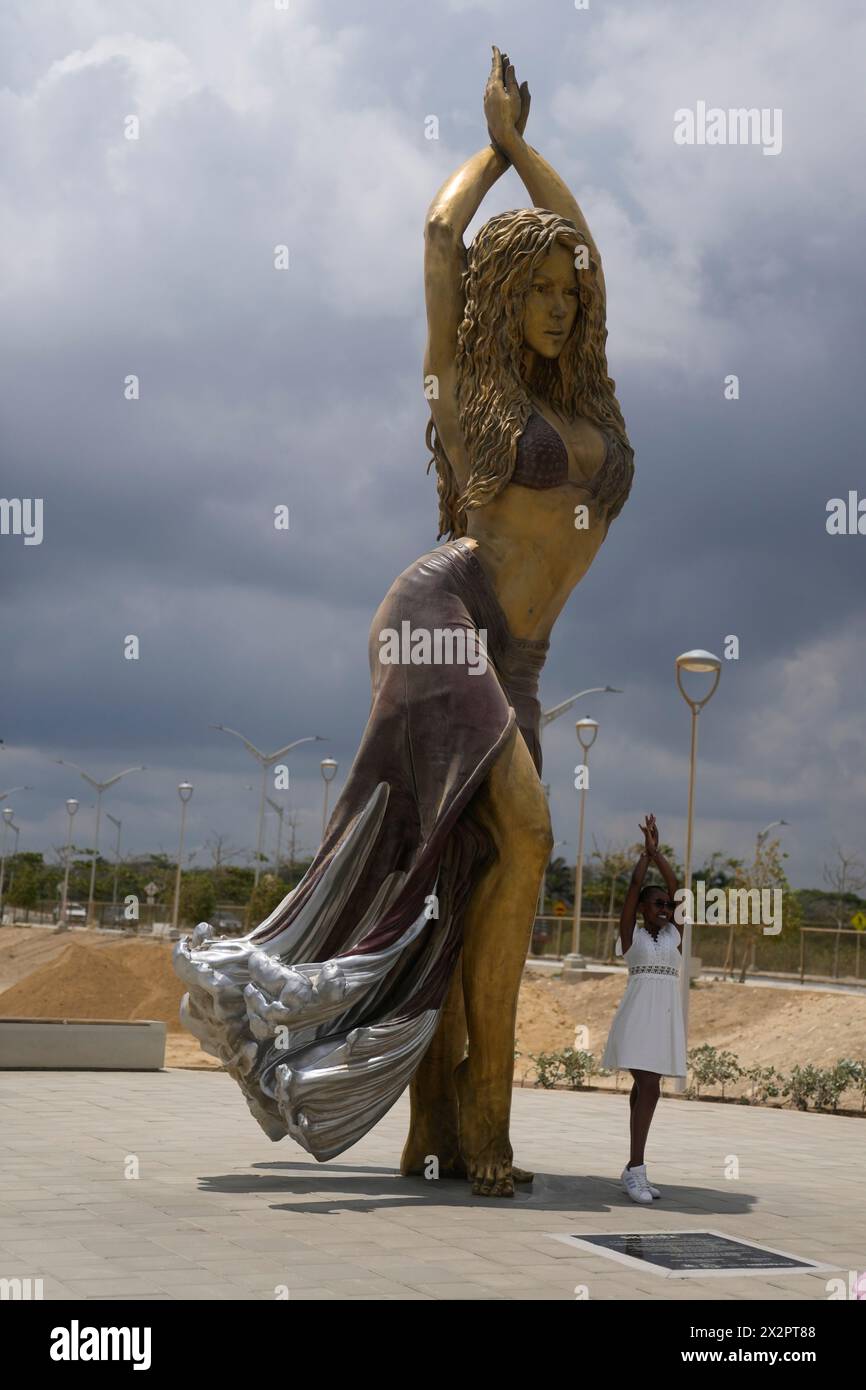 A tourist poses for photos in front of a statue of Colombian pop singer ...