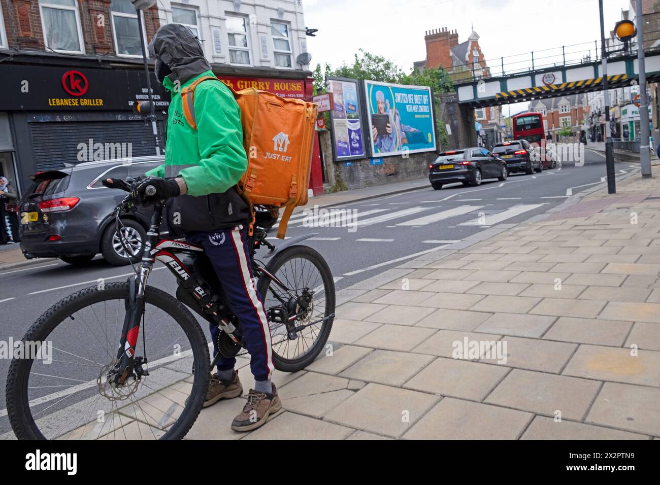 Just Eat food delivery courier cyclist standing by road on bicycle bike ...