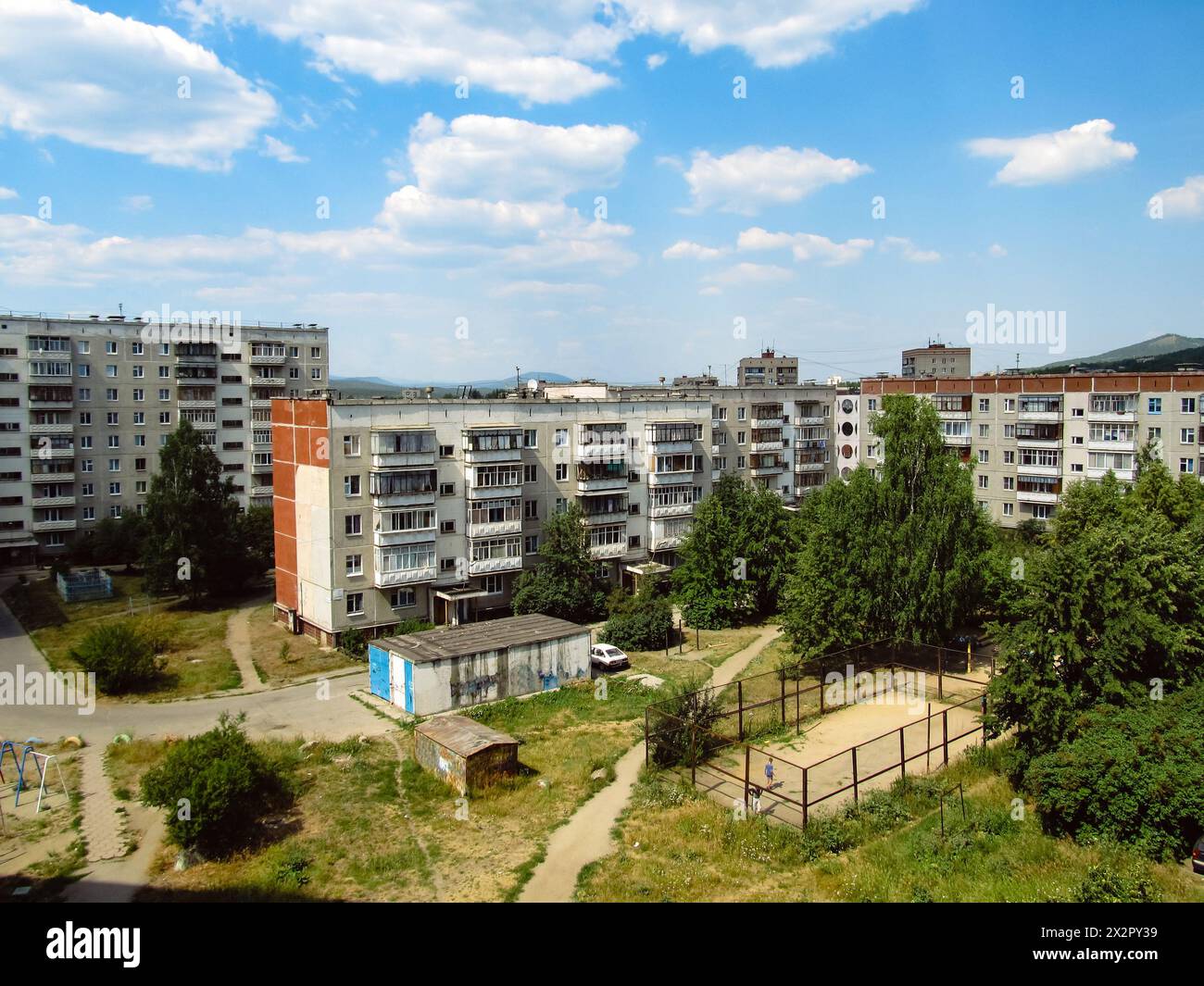 Residential high-rise buildings and a yard with trees against the ...