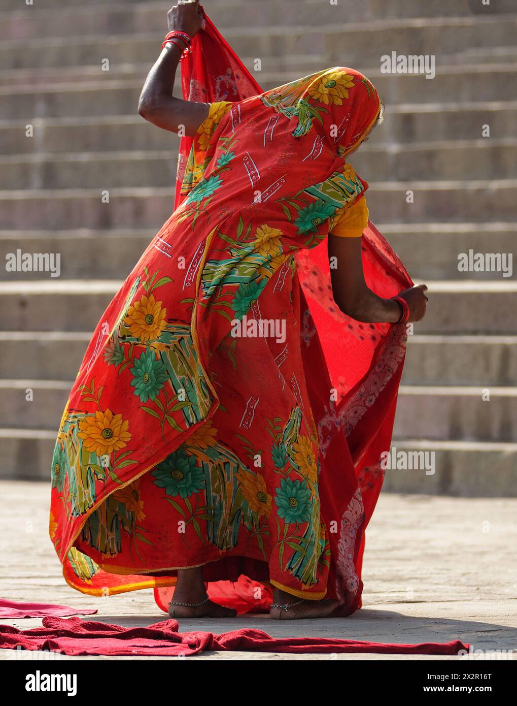 Woman drying her clothes after washing them in the nearby Ganges River ...