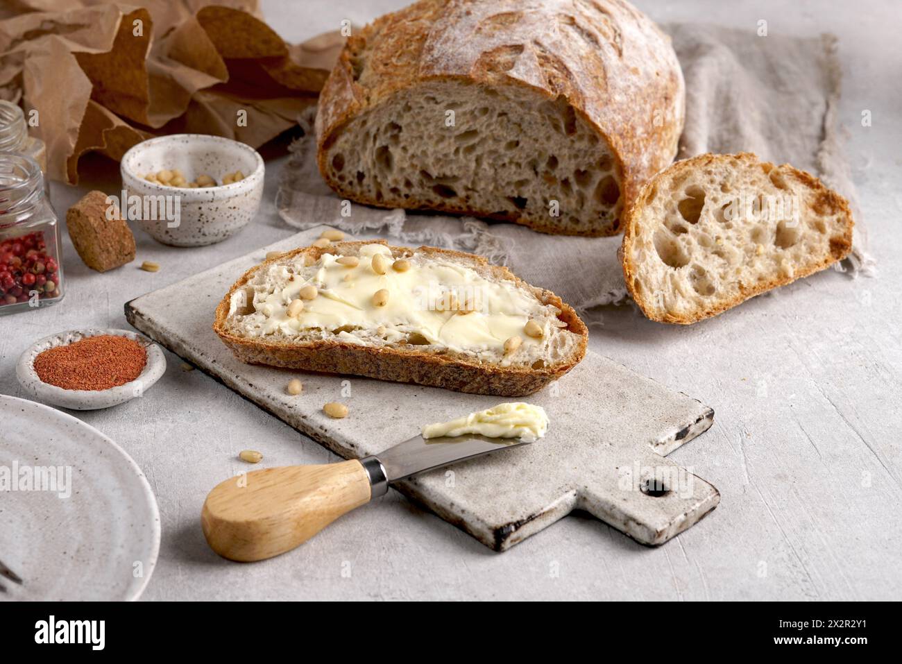 Artisan sliced toast bread with butter on cutting board. Simple ...