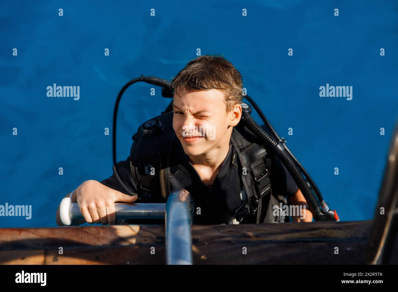 A close-up portrait of a fourteen-year-old teenager in a diving suit ...