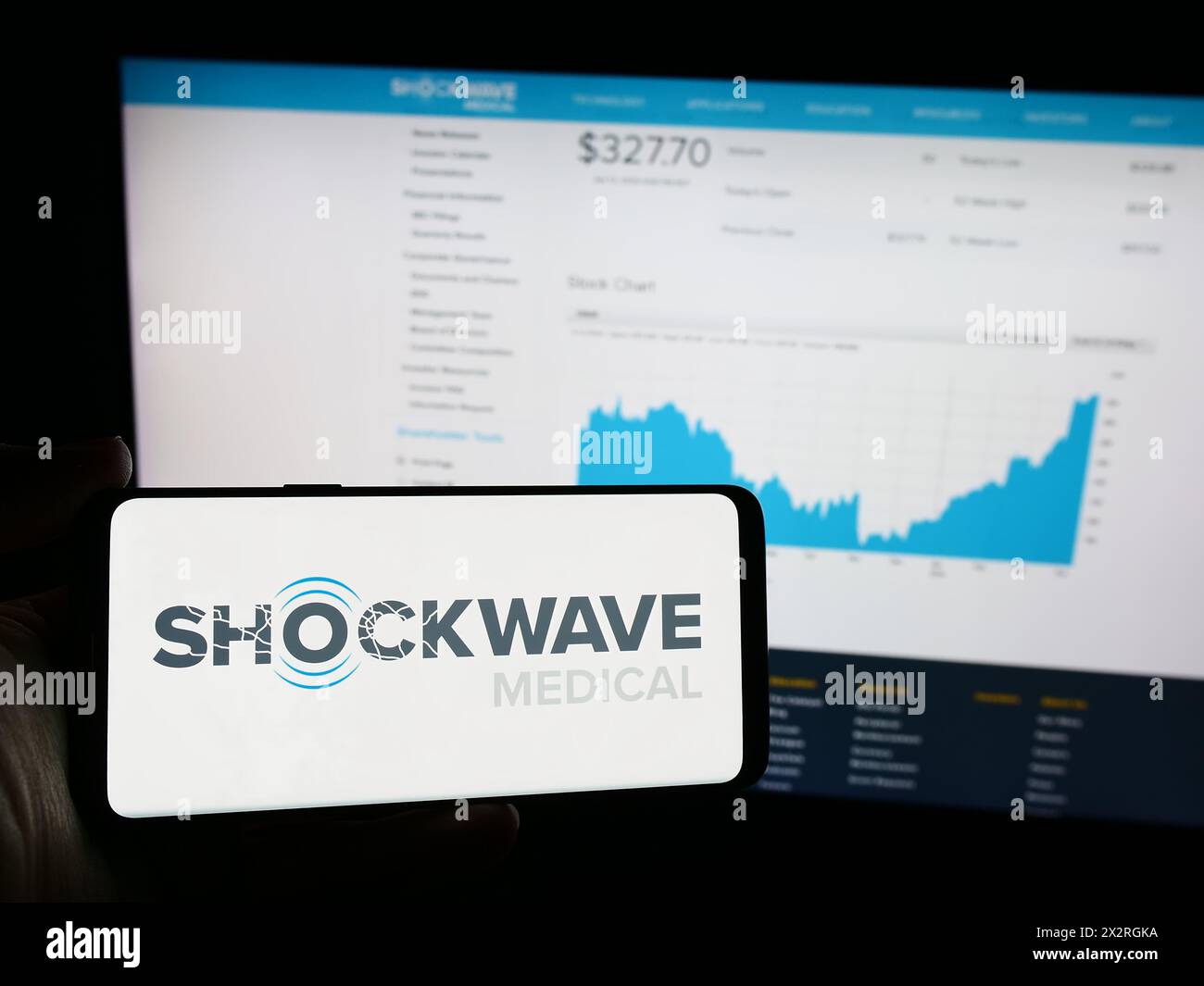 Person holding mobile phone with logo of US cardiovascular disease ...