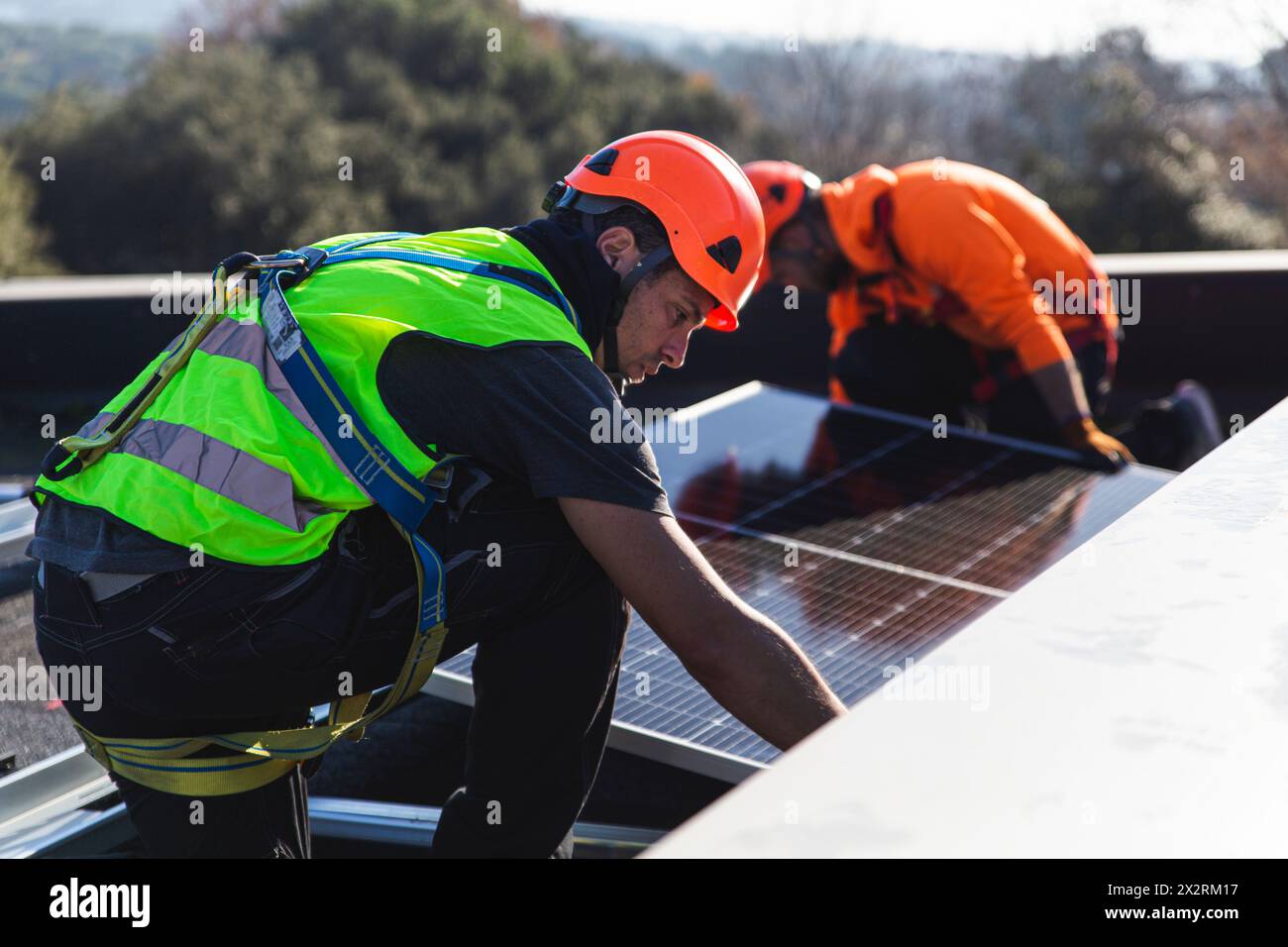Technician installing solar panel with coworker on rooftop Stock Photo - Alamy
