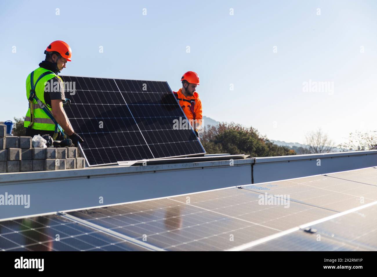 Two engineers installing solar panel on rooftop Stock Photo - Alamy