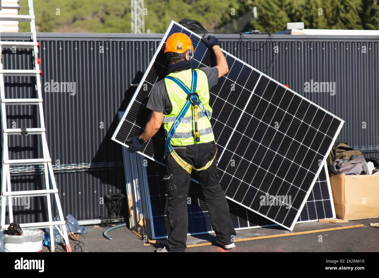 Mature technician carrying solar panel on rooftop Stock Photo - Alamy