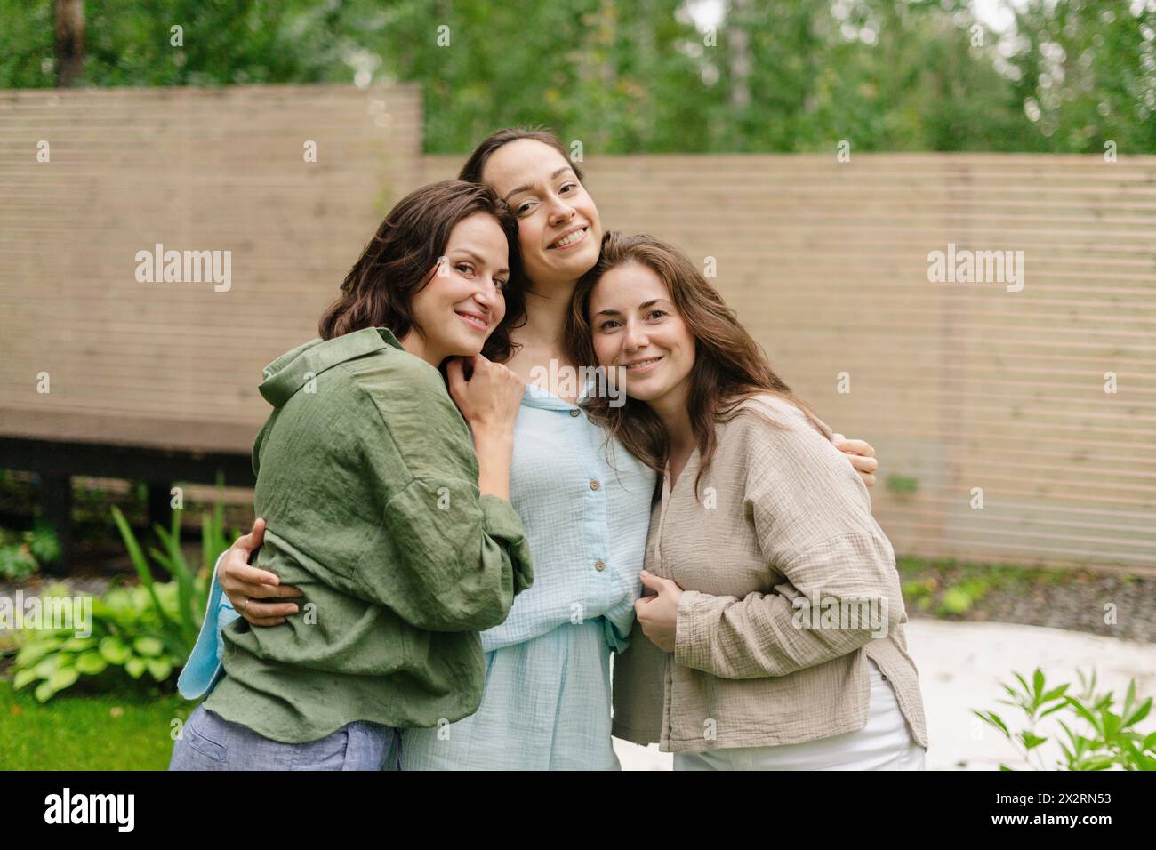 Smiling friends embracing together in back yard Stock Photo - Alamy