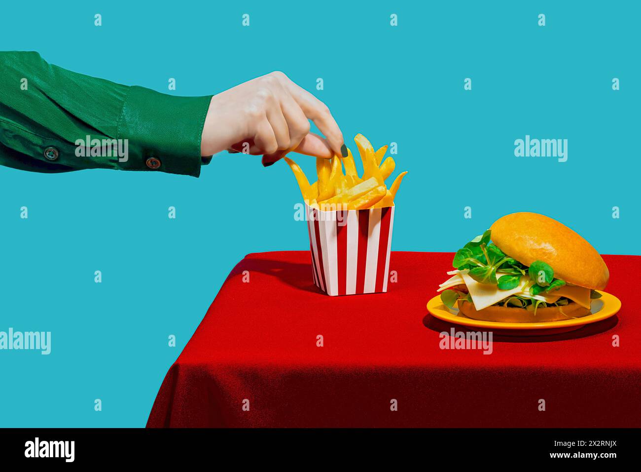 Hand of woman picking up french fries from table against blue ...