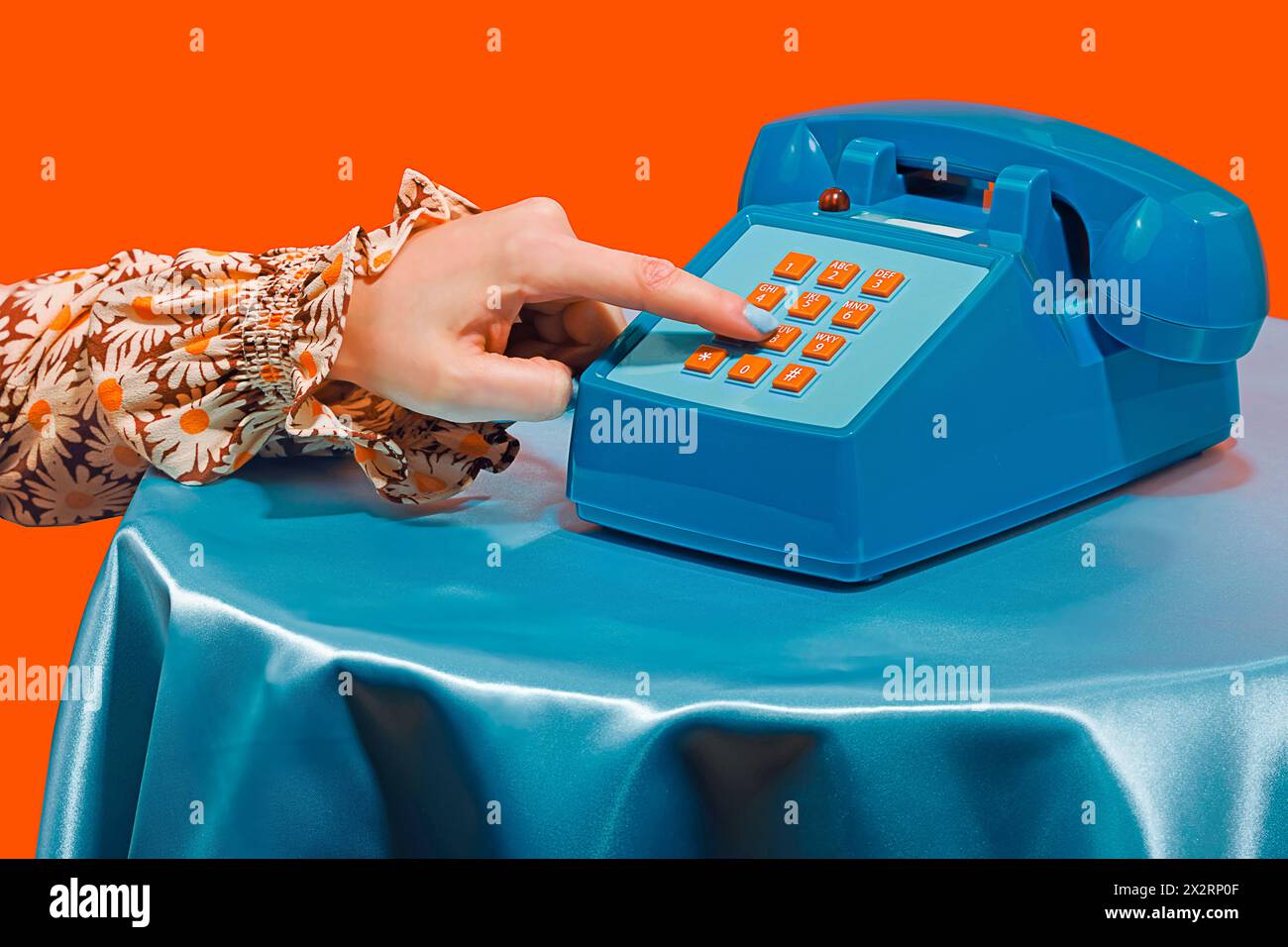 Woman dialing number on telephone against orange background Stock Photo ...