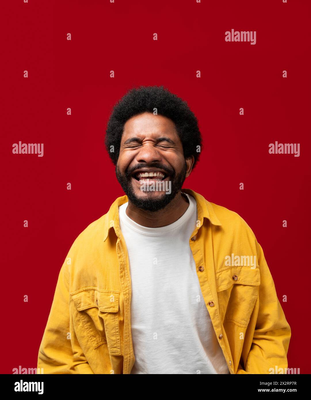 Happy man laughing against red background Stock Photo - Alamy