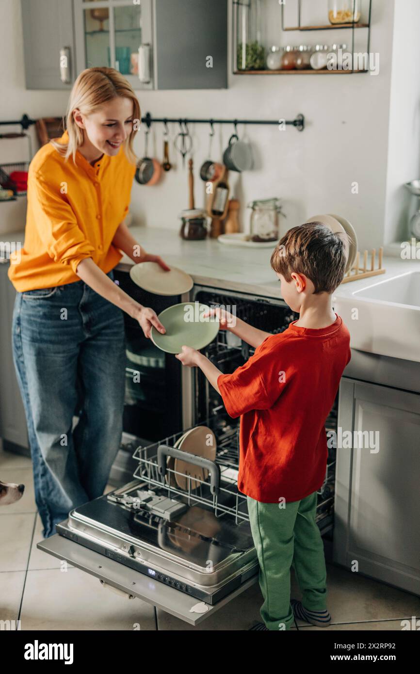 Mother and son washing dishes in kitchen at home Stock Photo - Alamy