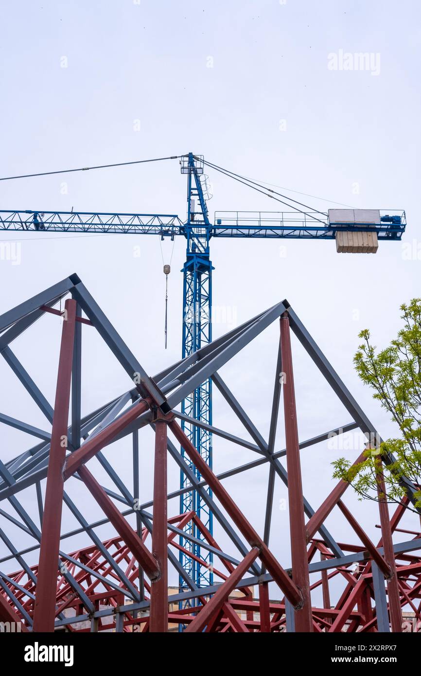 Portrait Geometric composition of red metal beams and a blue crane in a ...