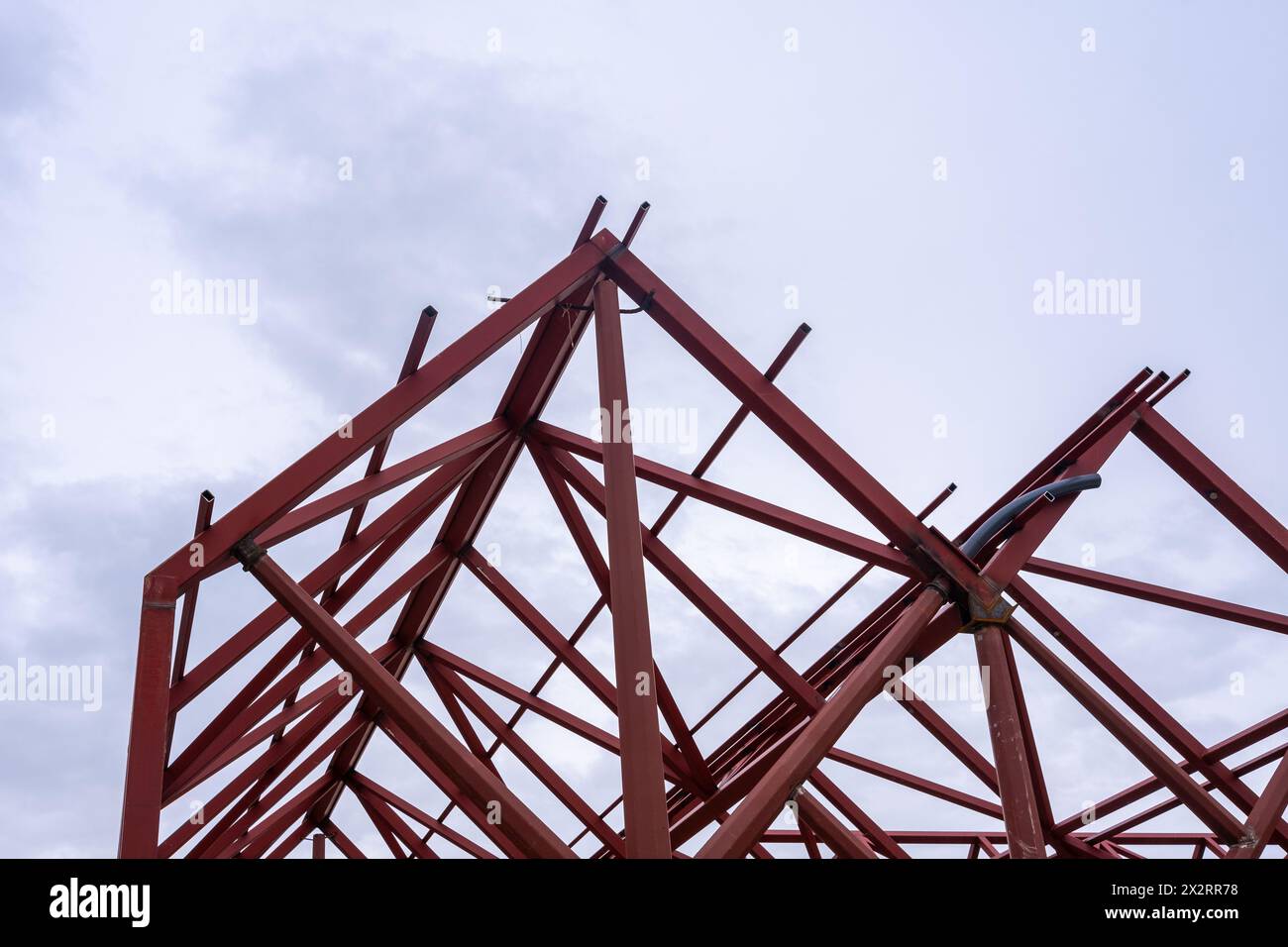 Geometric composition of red metal beams and a blue crane in a modern ...