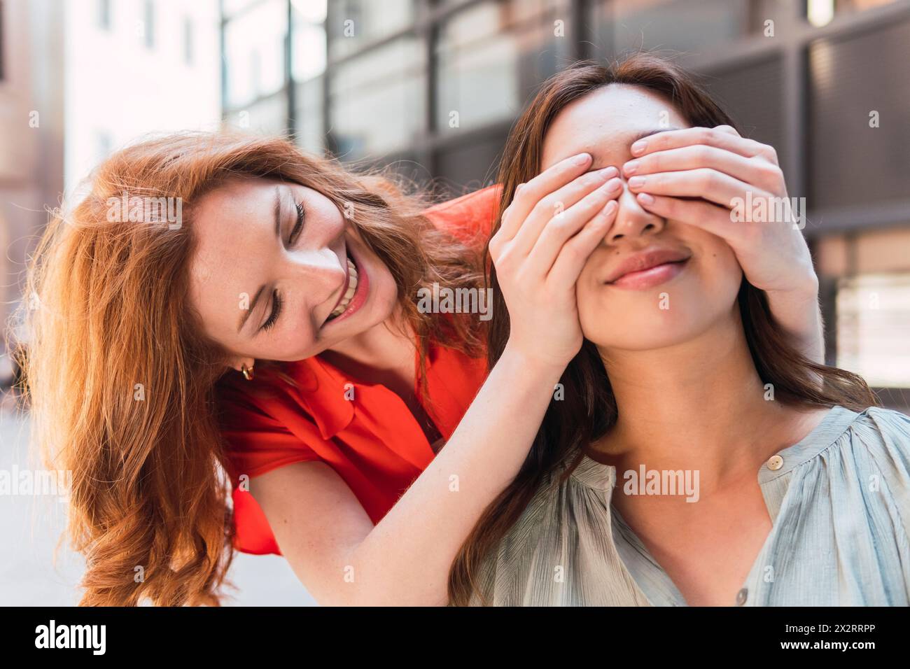 Woman covering friends eyes hi-res stock photography and images - Alamy
