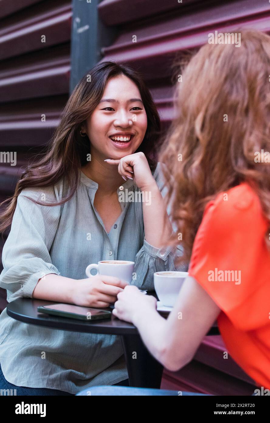 Two women having coffee talking cafe hi-res stock photography and ...