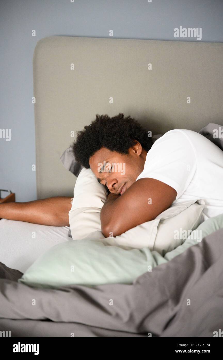 Man lying on bed sleeping in bedroom Stock Photo - Alamy