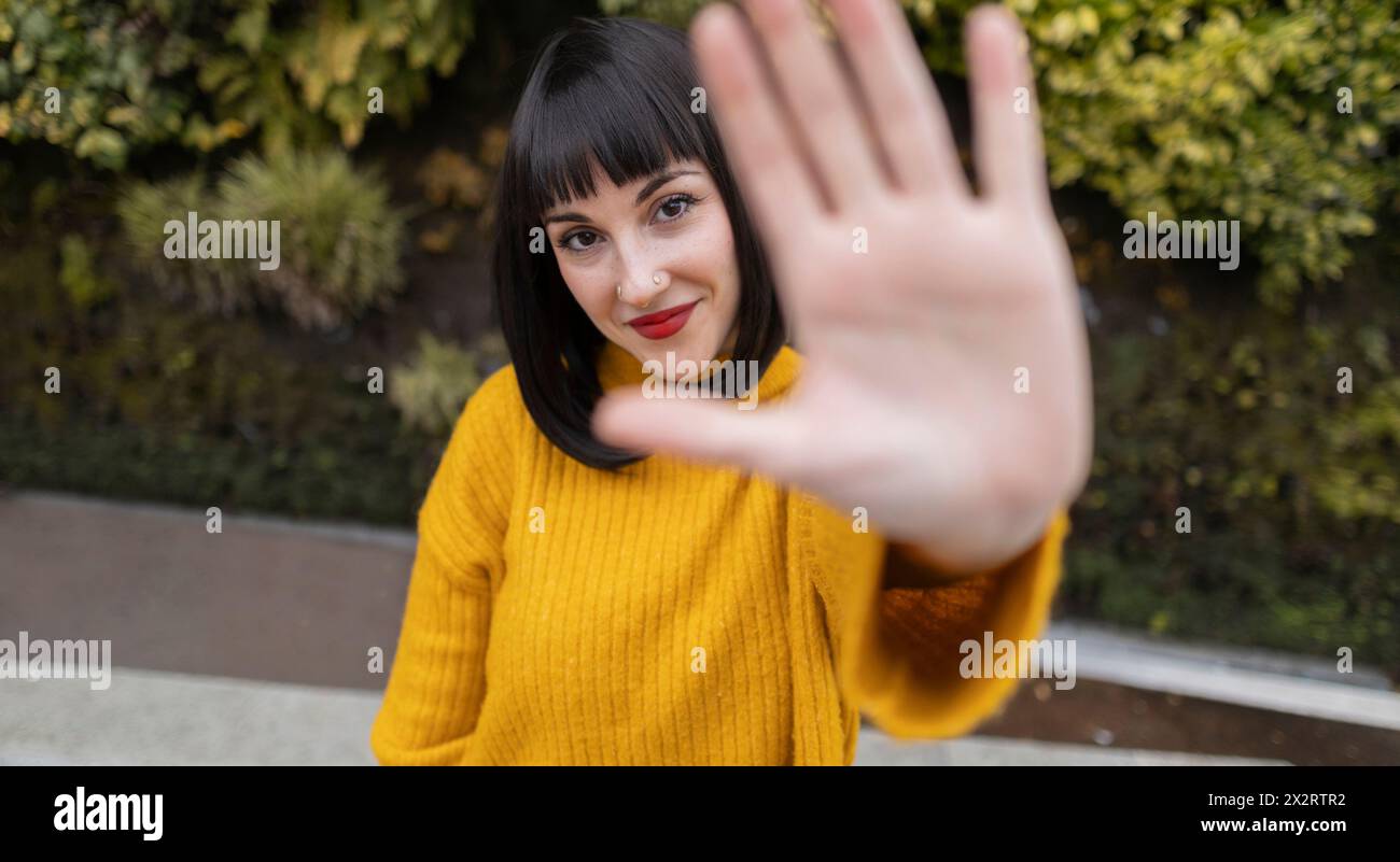 Woman with bangs doing stop gesture Stock Photo - Alamy
