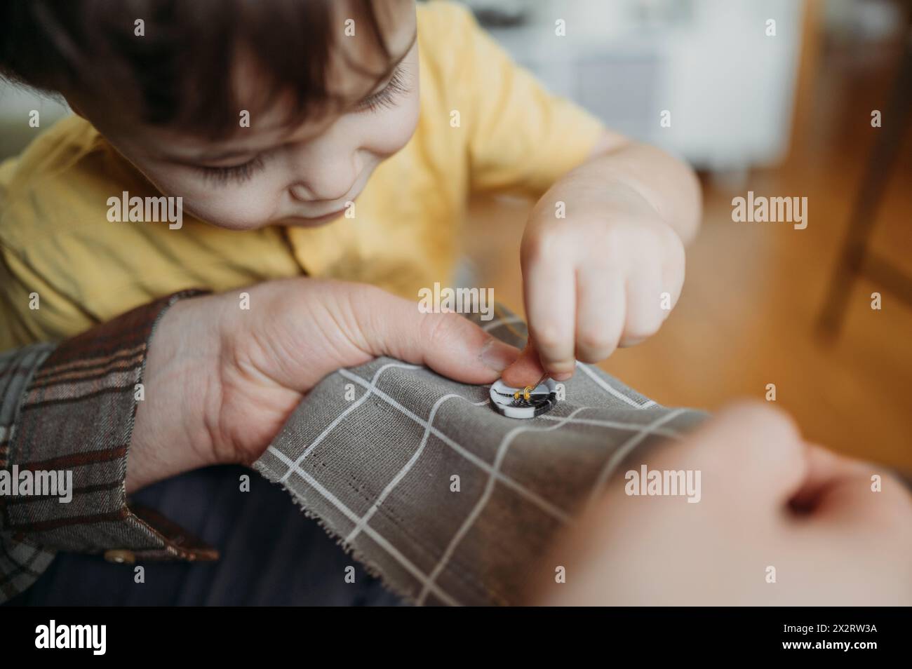 Father teaching son to sew button on cloth Stock Photo - Alamy