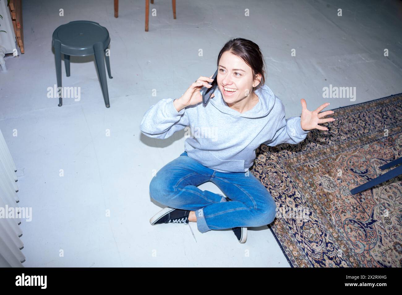 Excited woman laughing smartphone home hi-res stock photography and ...