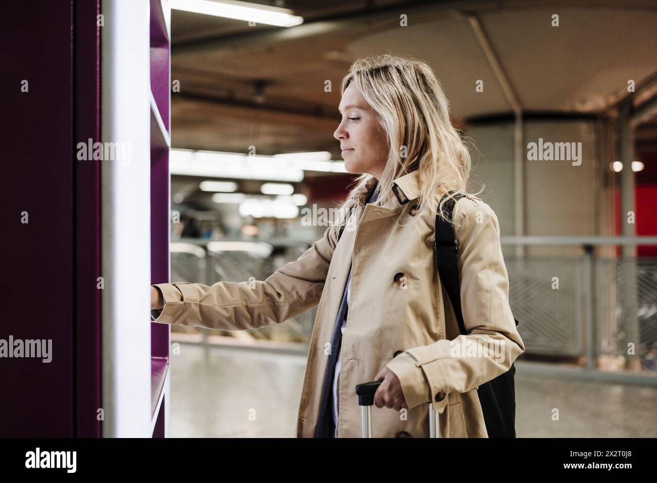 Woman using ticket vending machine at train station Stock Photo - Alamy