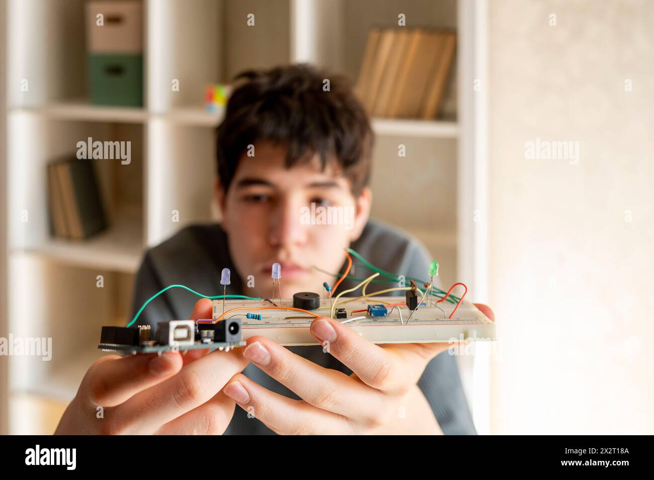 Teenage boy examining electrical semiconductor at home Stock Photo - Alamy