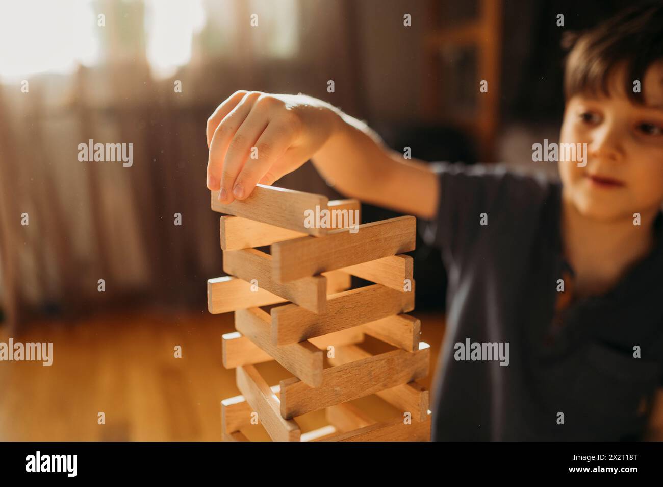 Boy stacking blocks and playing block removal game at home Stock Photo ...