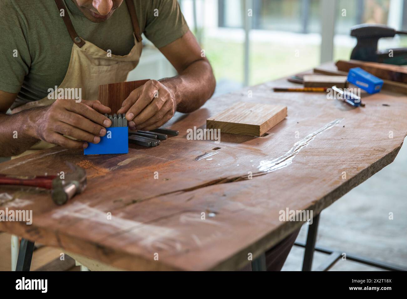 Carpenter using steel punch tool kit at workbench in woodshop Stock ...
