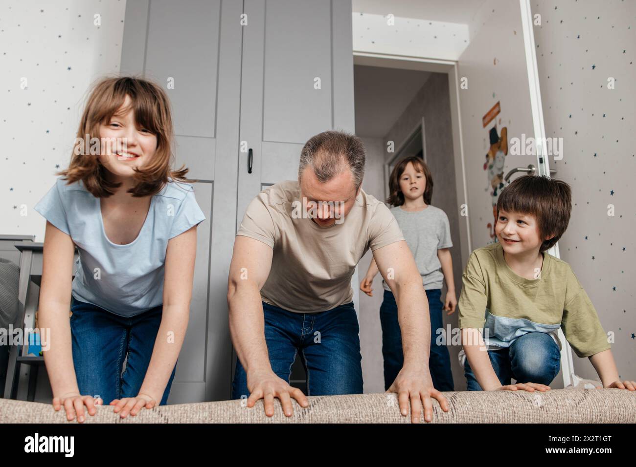 Children helping father in rolling carpet at home Stock Photo - Alamy