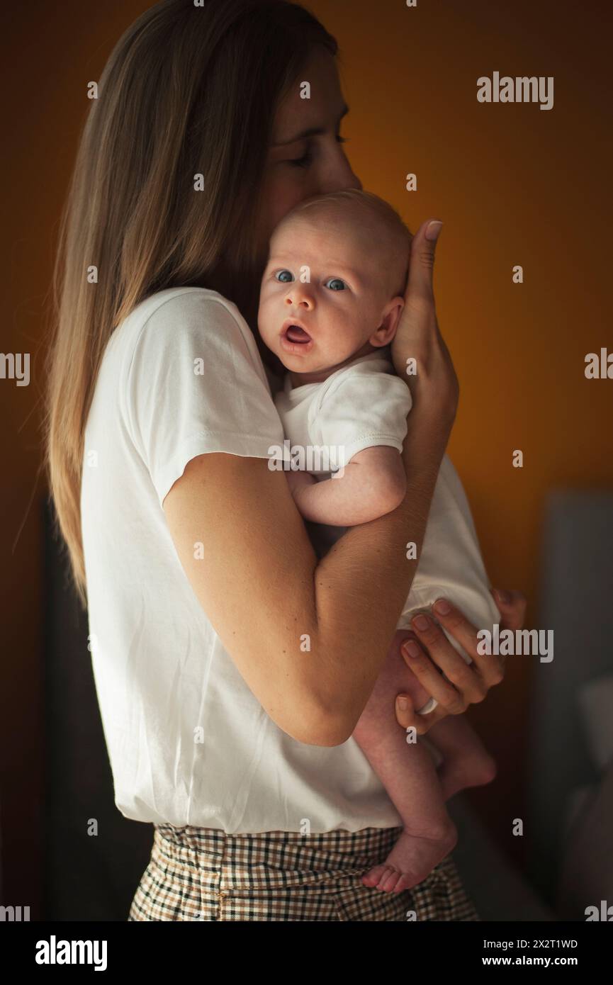 Mother hugging baby boy in arms at home Stock Photo - Alamy