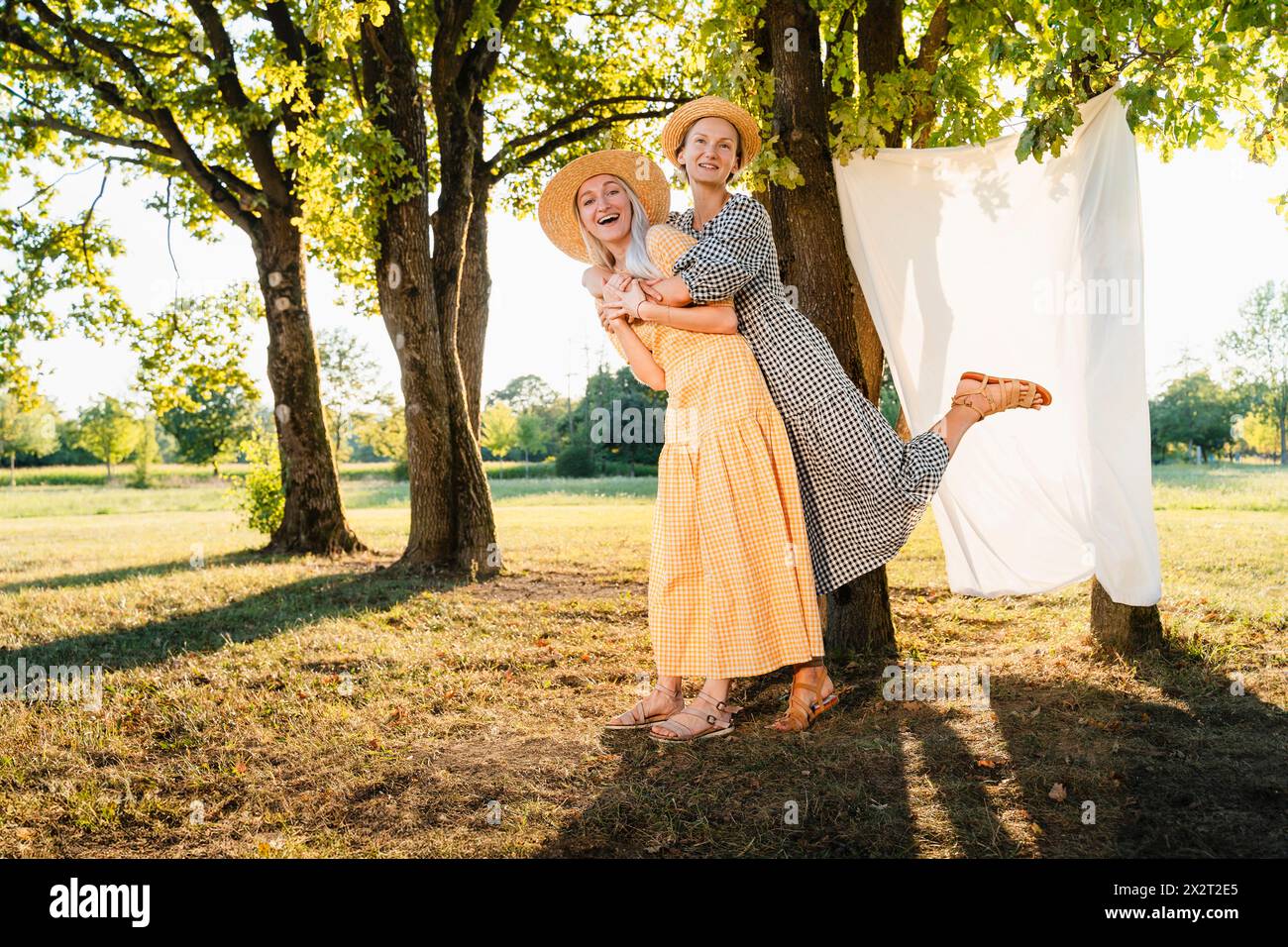 Happy woman carrying friend on piggyback in park Stock Photo - Alamy