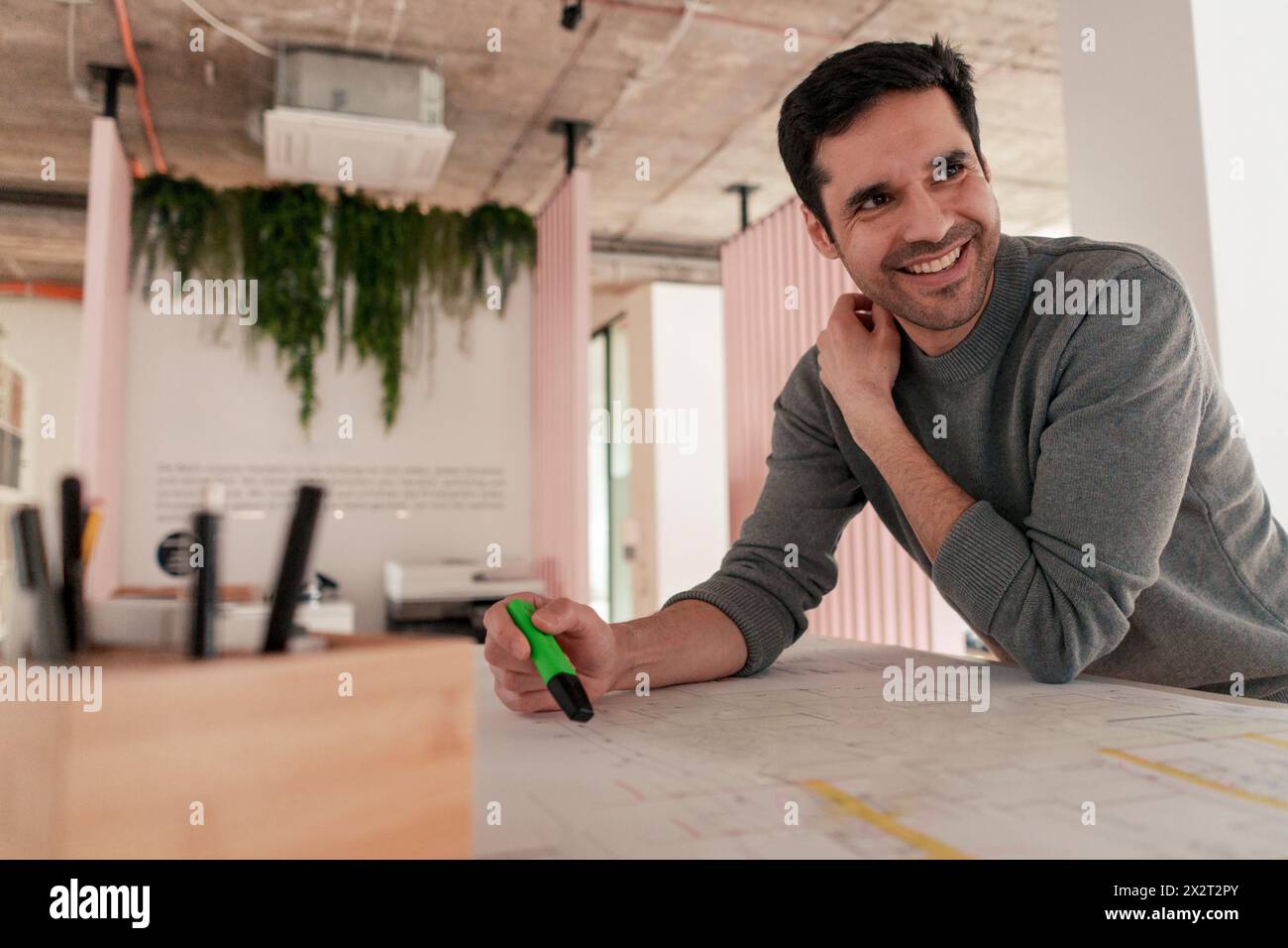 Happy architect sitting with blueprint at desk Stock Photo - Alamy Happy architect sitting with blueprint at desk Stock Photo - Alamy