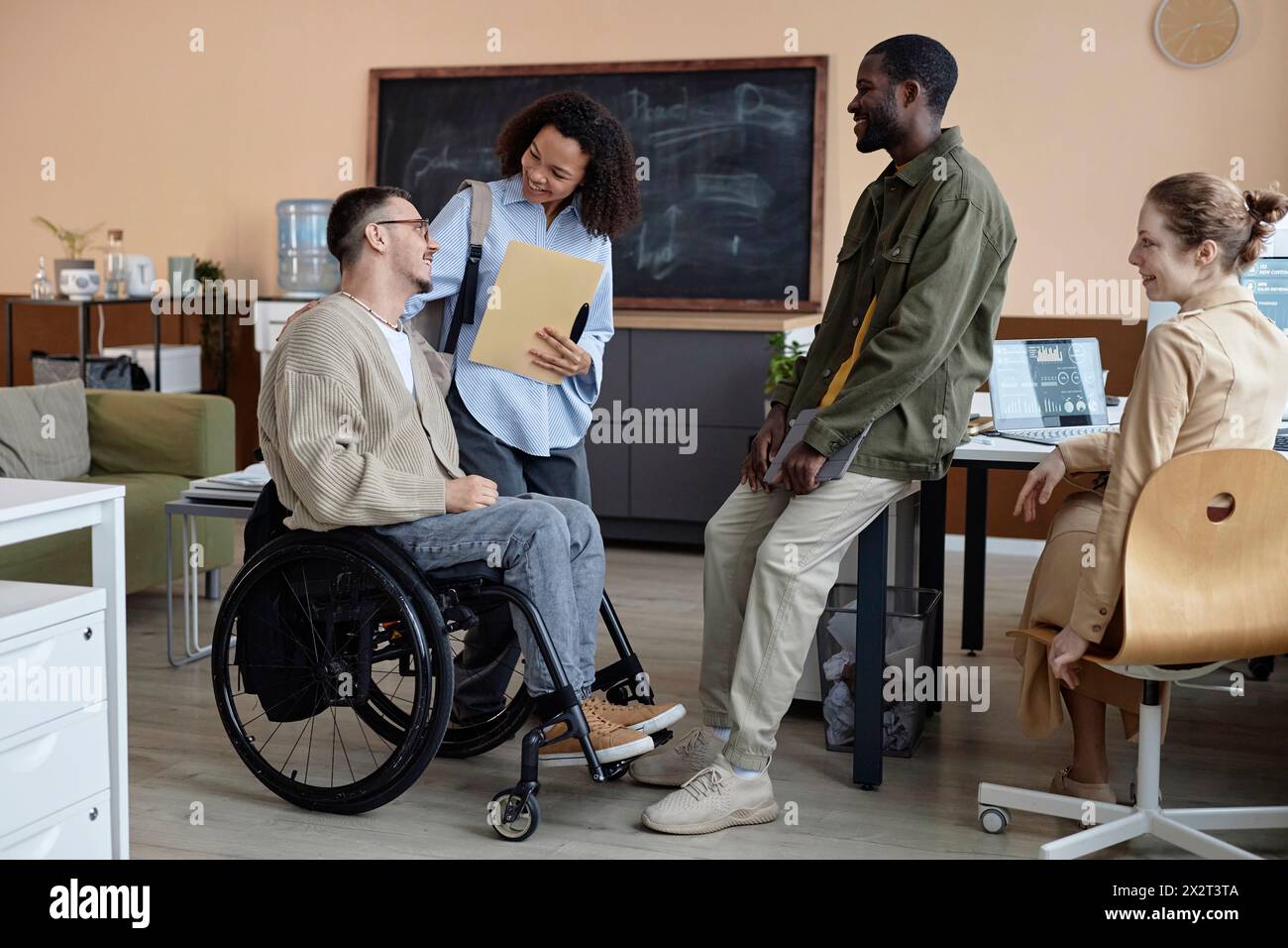 Happy business people supporting disabled colleague in office Stock ...